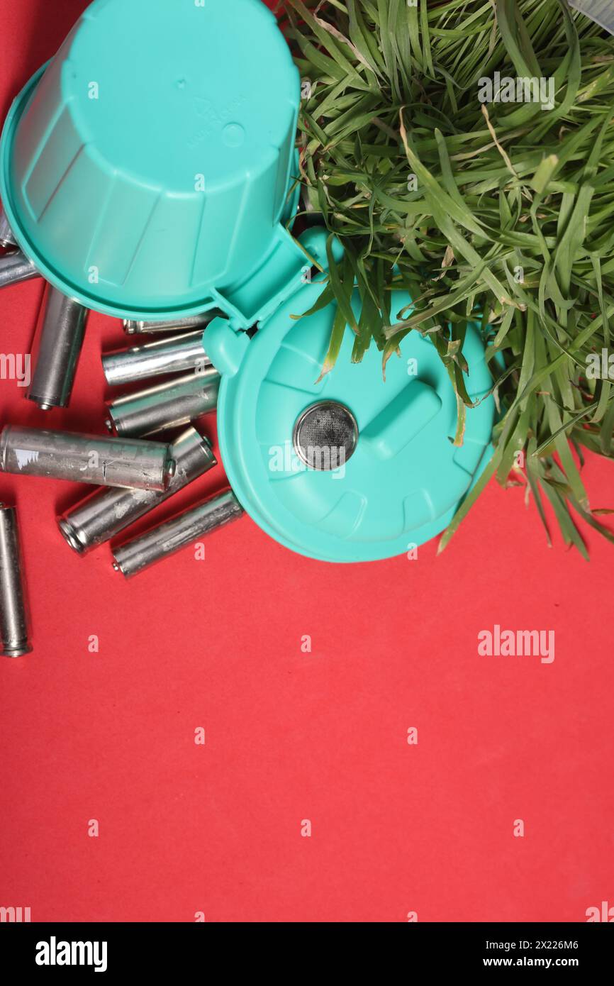 Used finger batteries in a miniature trash can. Fading greens.Pink ...