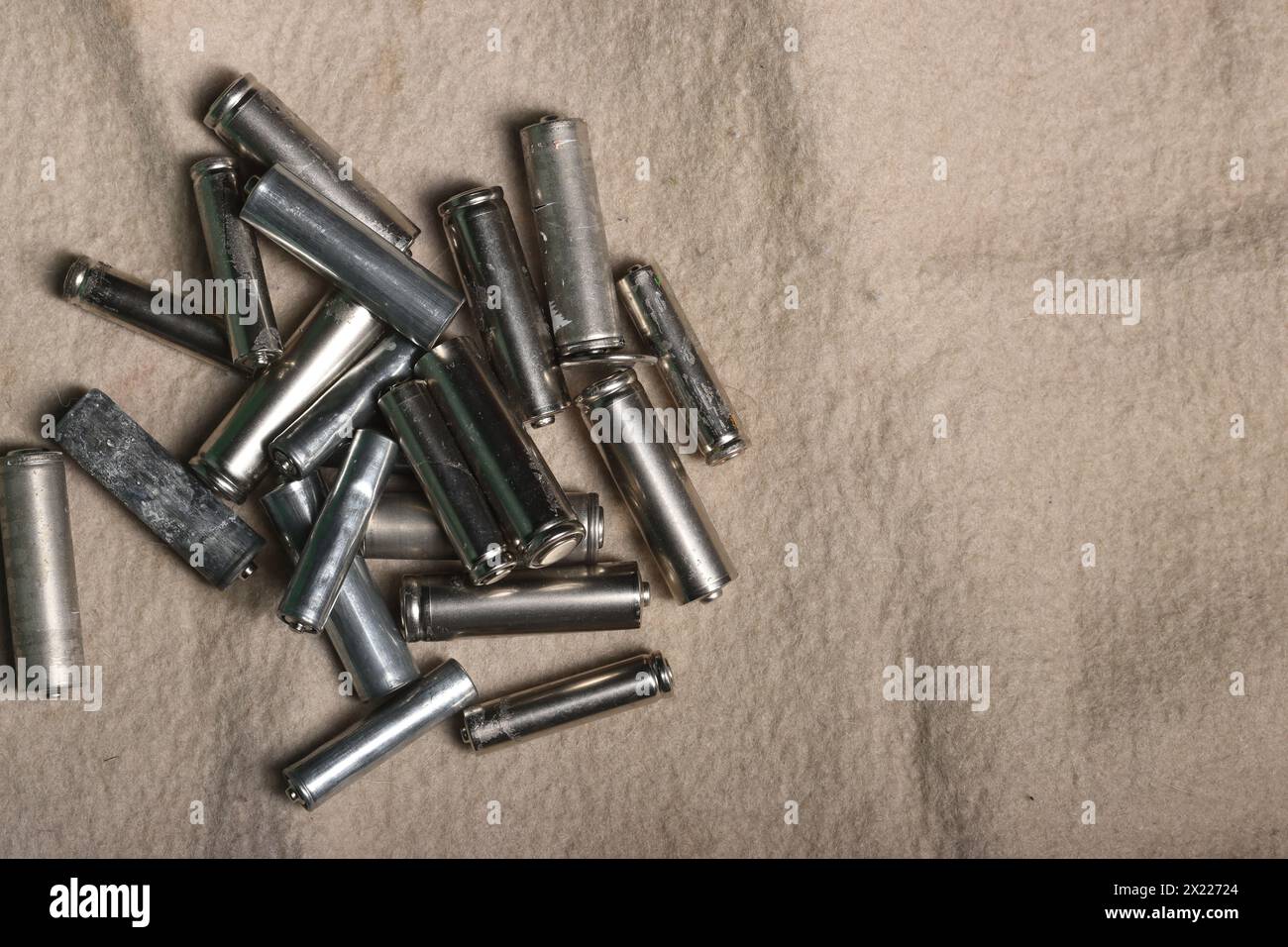 Used finger batteries on a beige dirty background. Recycling of waste ...