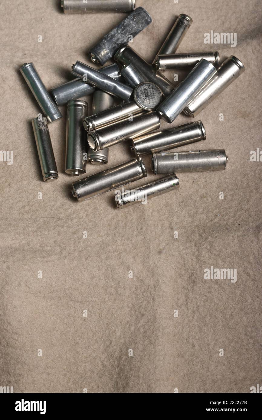 Used finger batteries on a beige dirty background. Recycling of waste ...