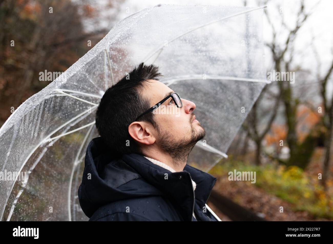 A reflective moment captured as a man looks upwards, shielded by a ...