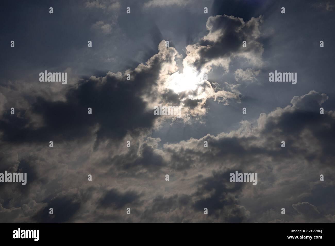 Cloudscape of sky with heavy rain backdrop. The bright sun behind the ...