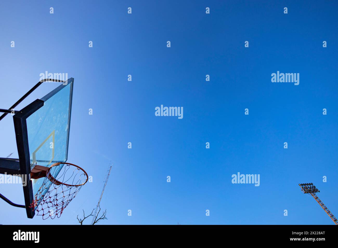 Basketball hoop over the blue sky and sport light pole Stock Photo - Alamy
