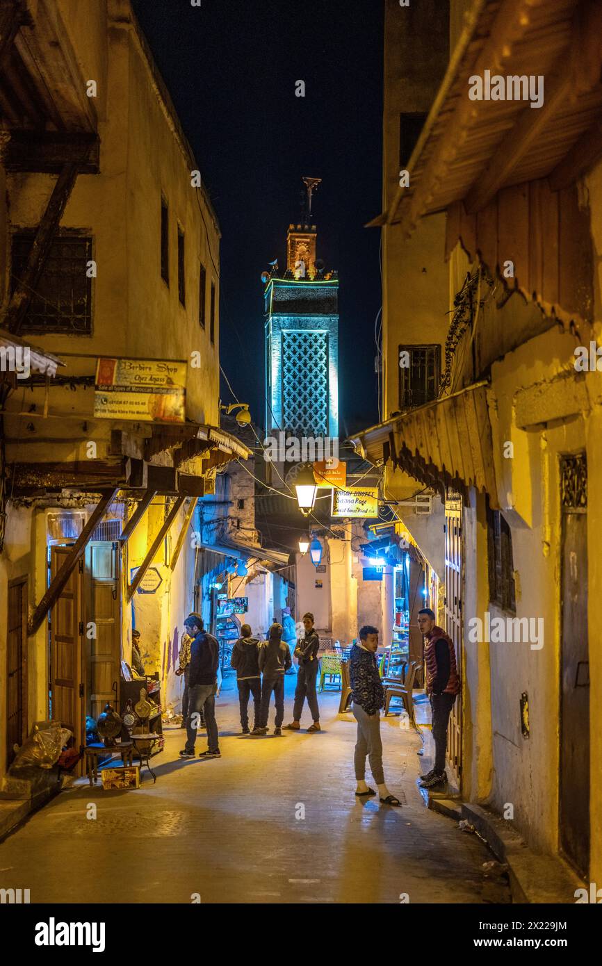 A group of people standing on a narrow alleyway at night in the Medina ...