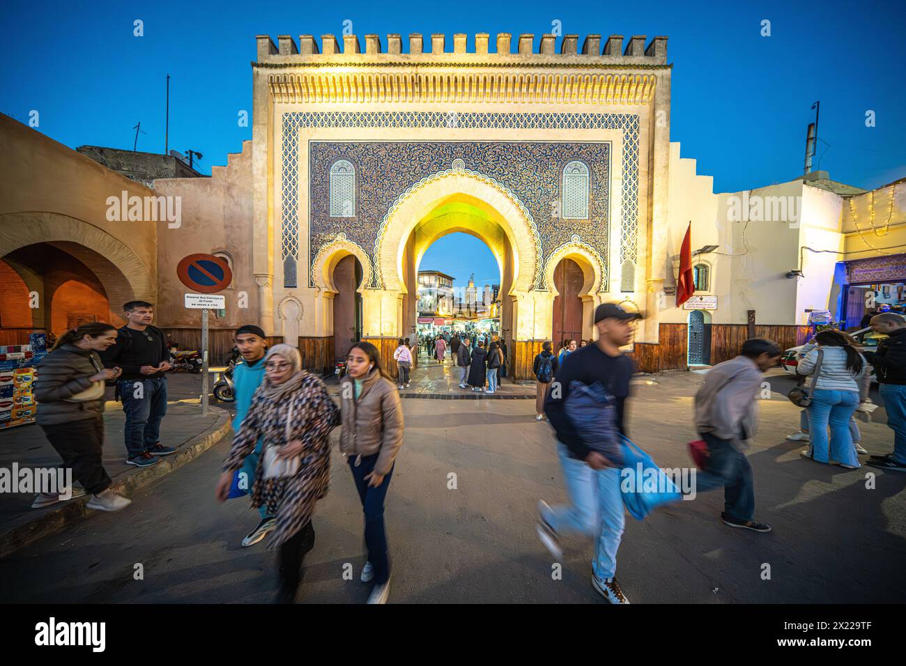 A group of people walking in front of the historic Bab Boujloud, also ...