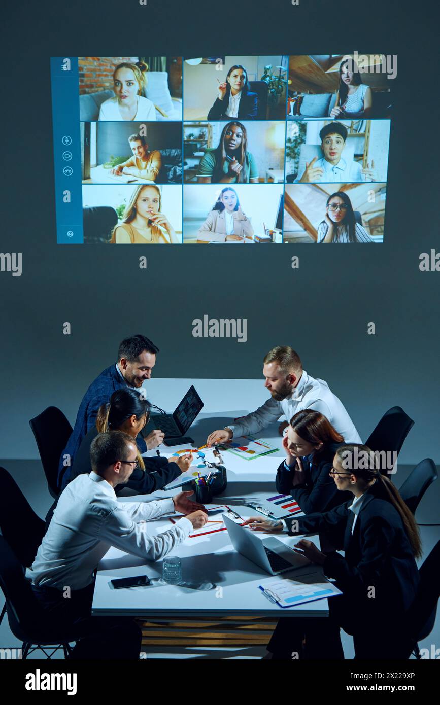 Business professionals seated around table in office conference room ...