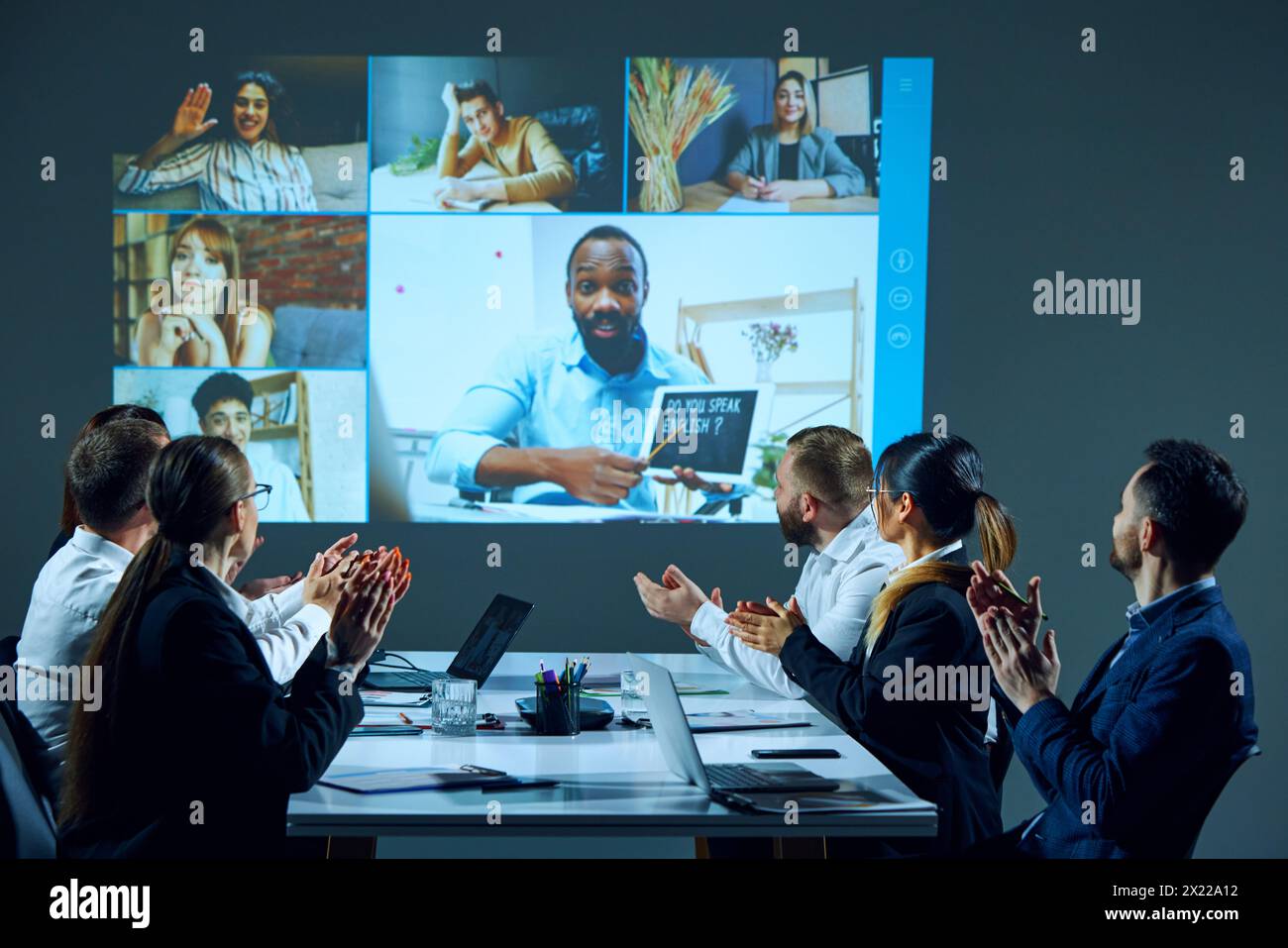 Office workers gather around conference table, engaged in online ...