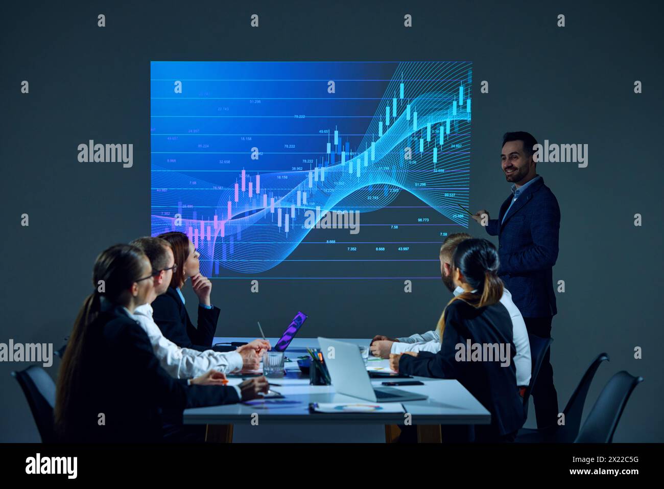 Colleagues in corporate environment gather in boardroom, studying ...