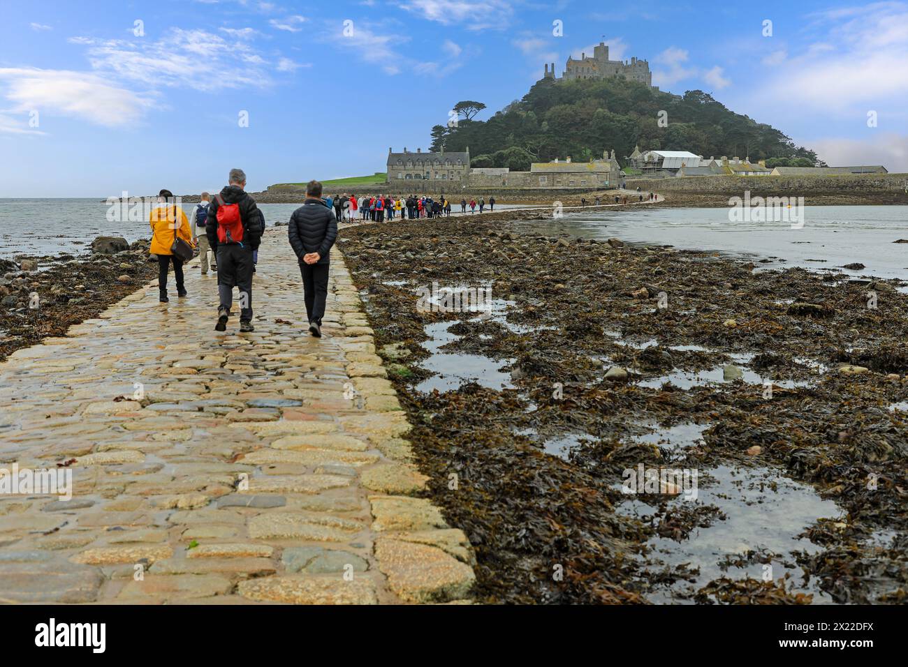 Tourists walking on the tidal causeway to St Michael's Mount, a tidal ...