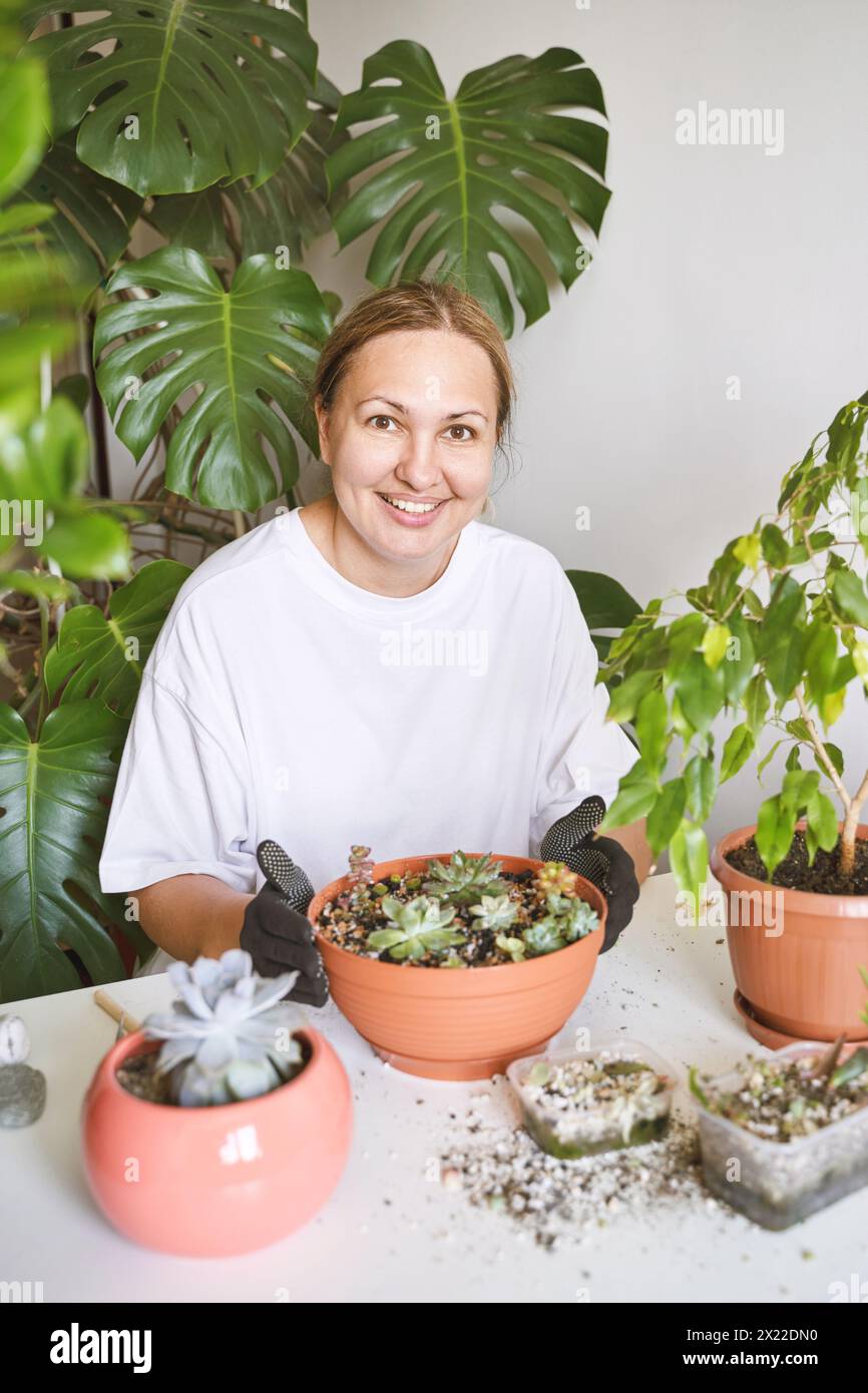 In a cozy room, a smiling woman tends to her beloved plants with care ...