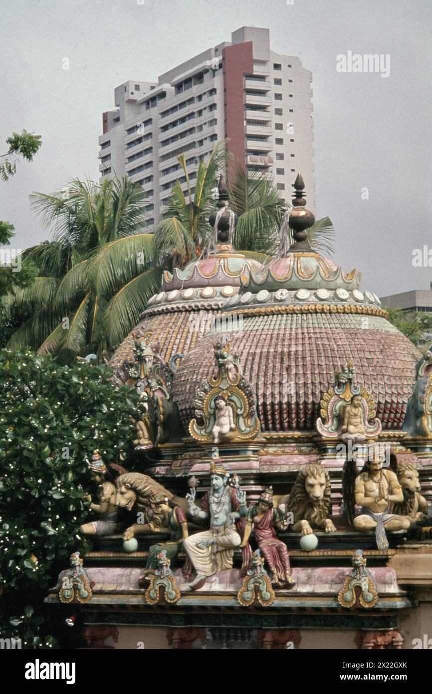 A modern high-rise building behind the dome of a temple in Singapore ...