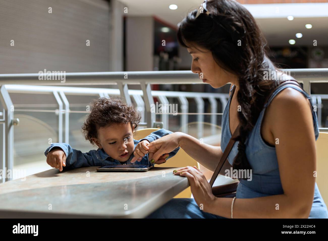 Mom and her Latin American son sitting playing with the cell phone. The ...