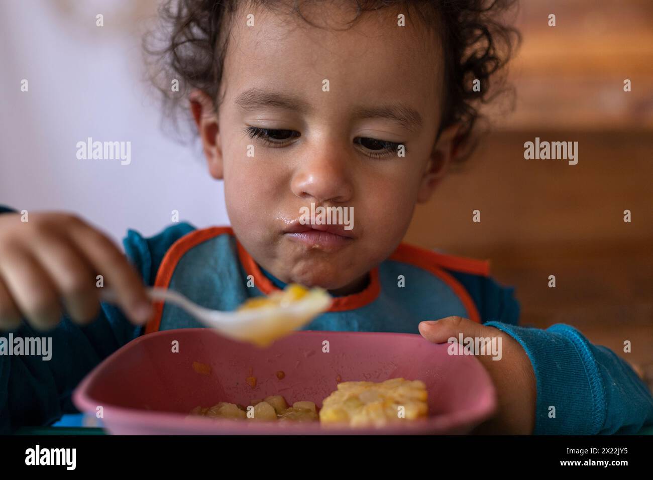 Latin American child (2) eating soup with vegetables for lunch, learned ...