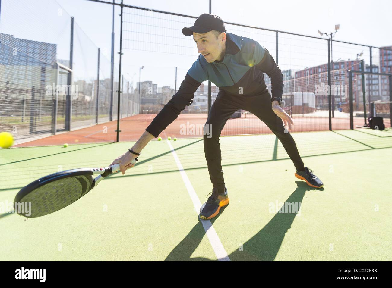 paddle tennis coach teaching on a residential paddle court, front view ...