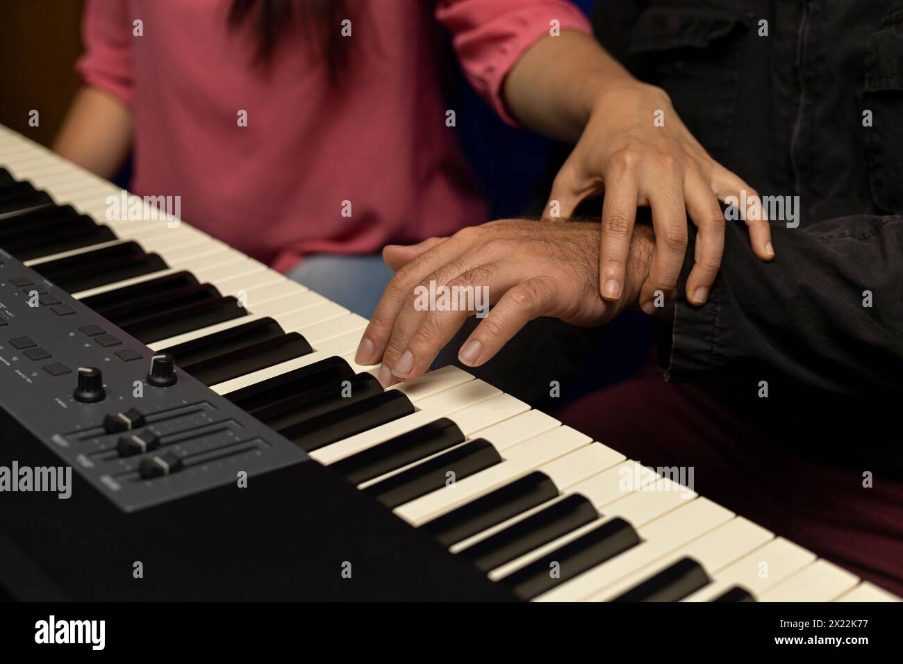 Unrecognizable Latin American teacher teaches and corrects the posture ...