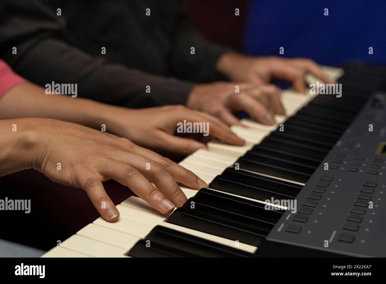 Latin American teacher plays the piano keyboard with her student with ...