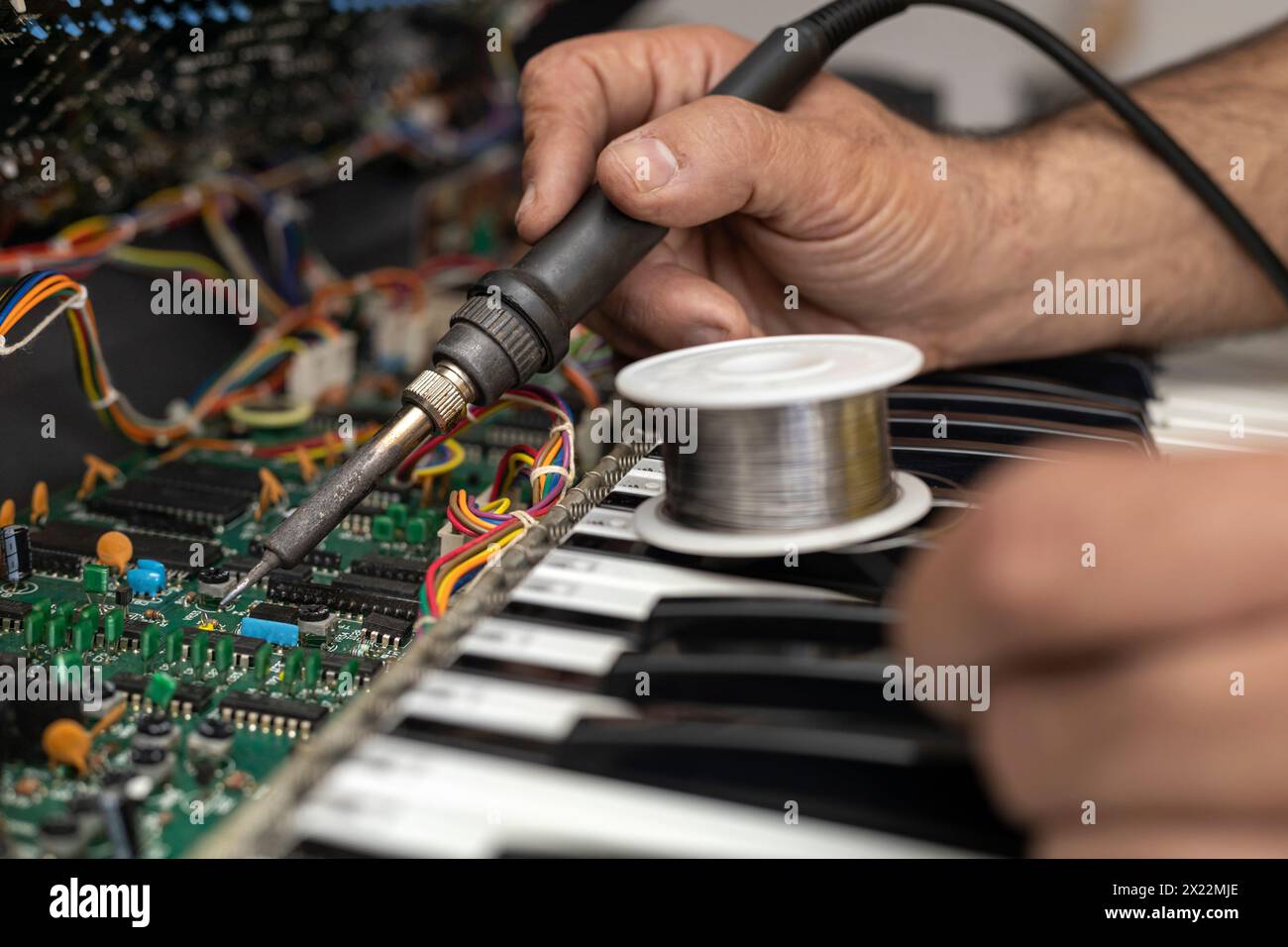 Hands of Latin American electronic technician repairing the circuit of ...