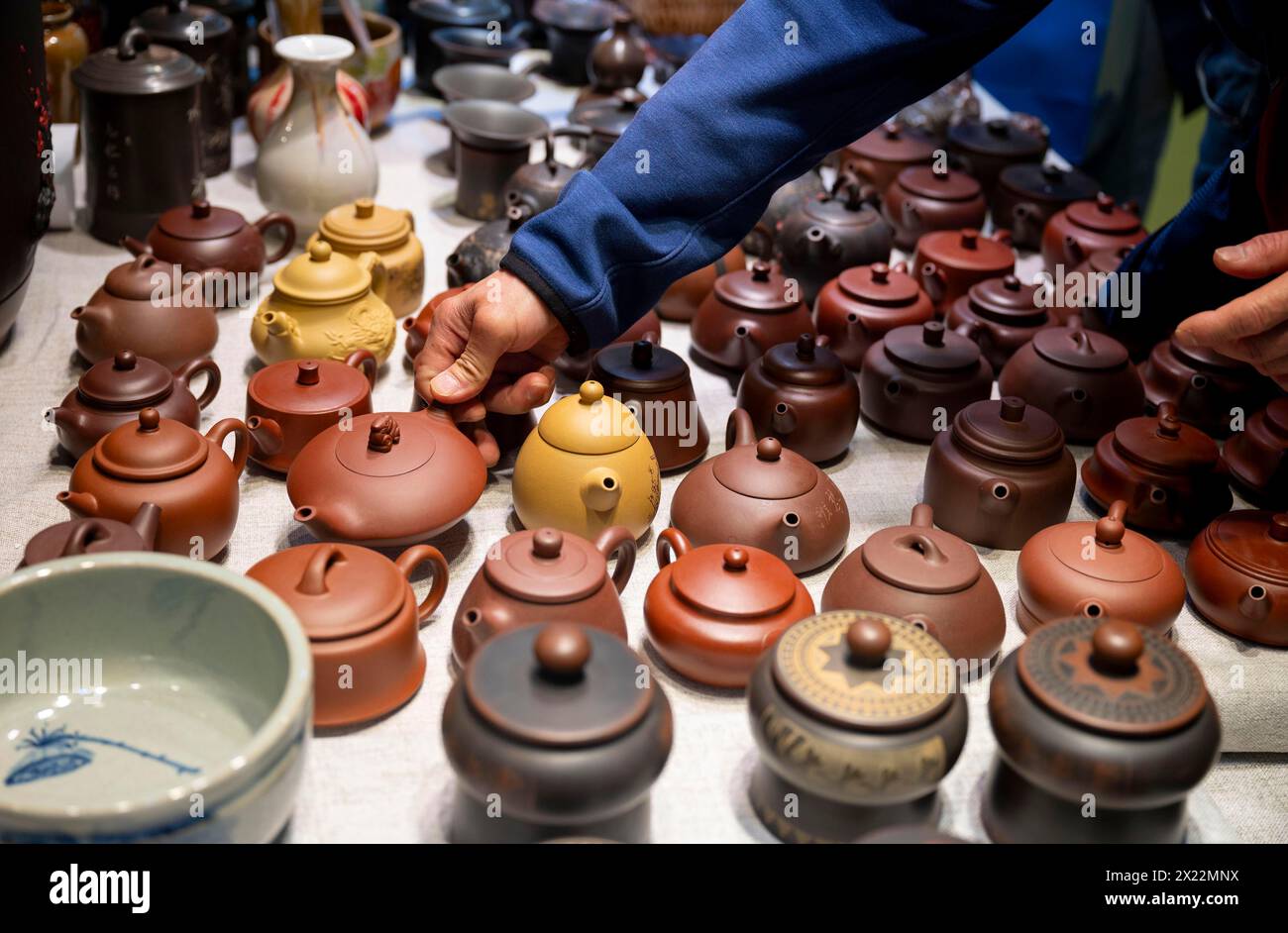 Beijing, China. 19th Apr, 2024. A visitor selects teapots at the 16th ...