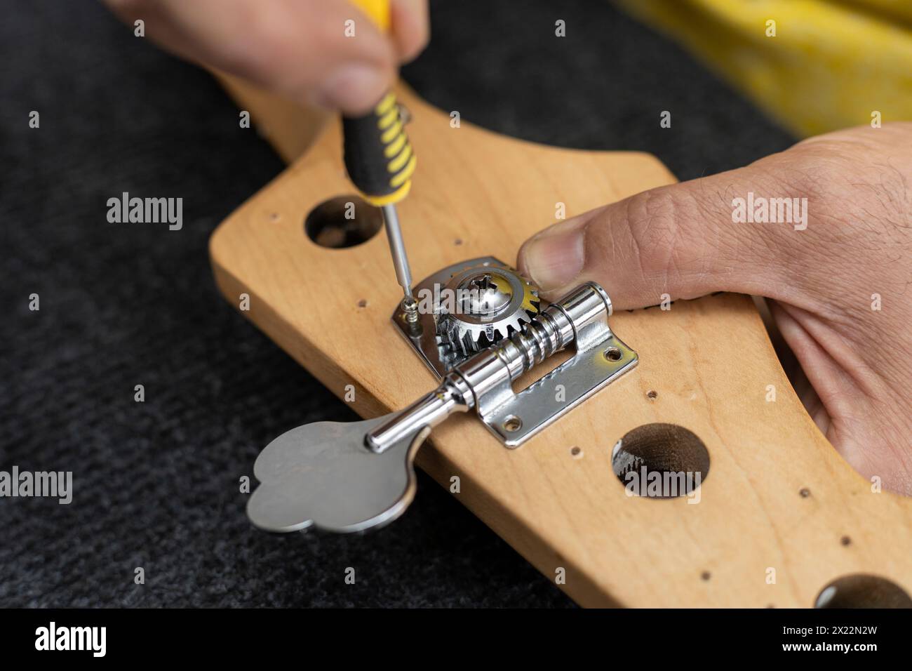 Latin American luthier's hands placing and adjusting with a screwdriver ...