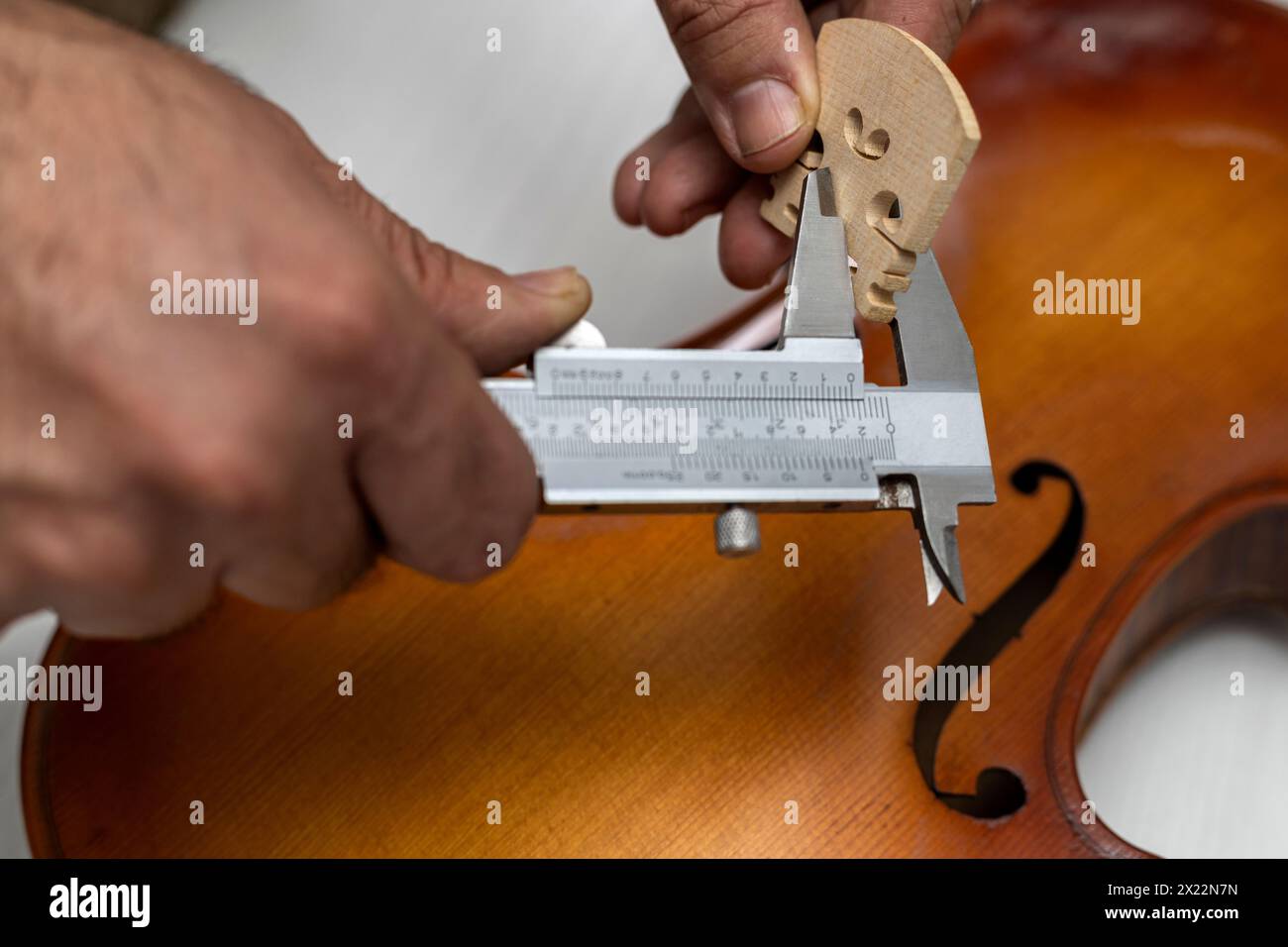 Hands of an unrecognizable Latin American luthier taking precise ...