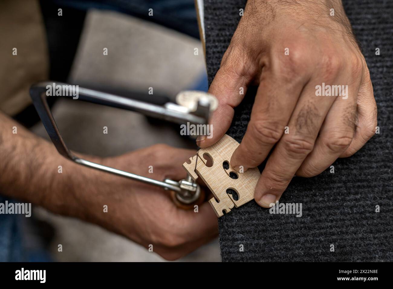 Top view of unrecognizable Latin American luthier using a hacksaw to ...