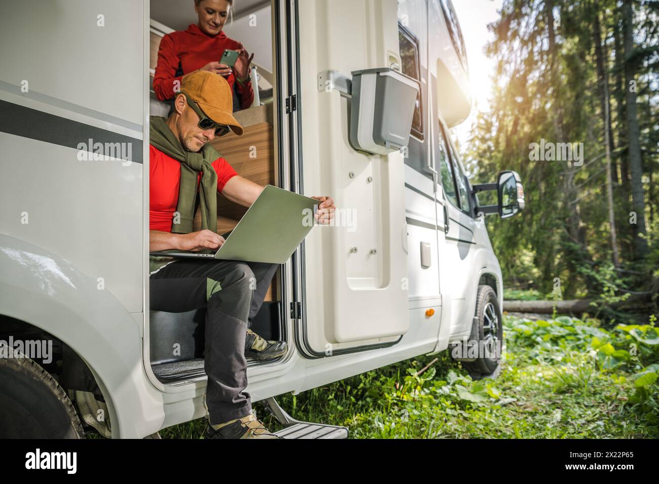 Caucasian Couple Using Internet While Traveling in a Camper Van Stock ...
