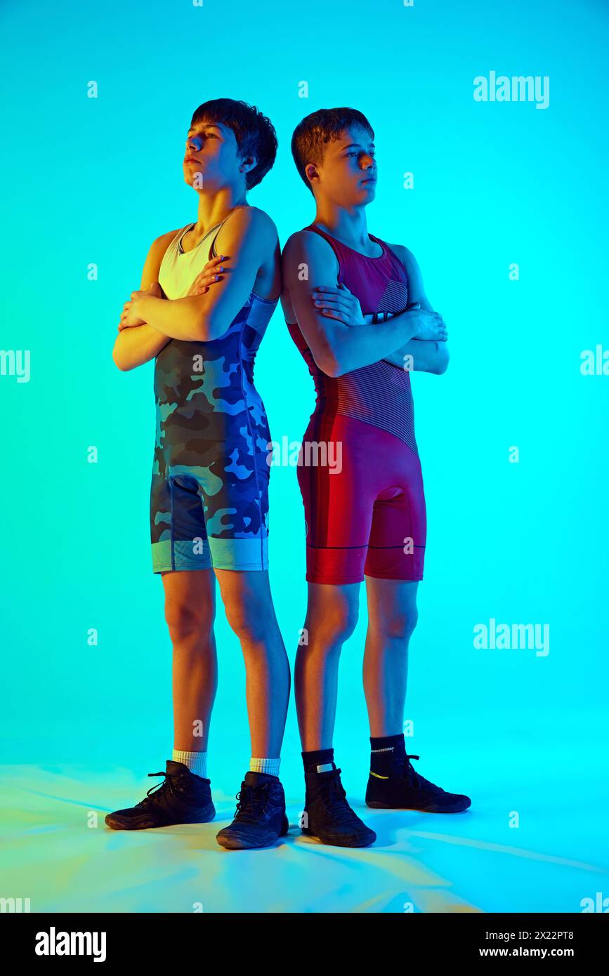 Two male wrestlers standing, face off in physical contest, each aiming ...