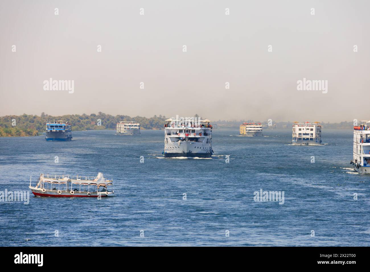 Flottilla of Nile Cruise ships with local ferry crossing thier paths ...