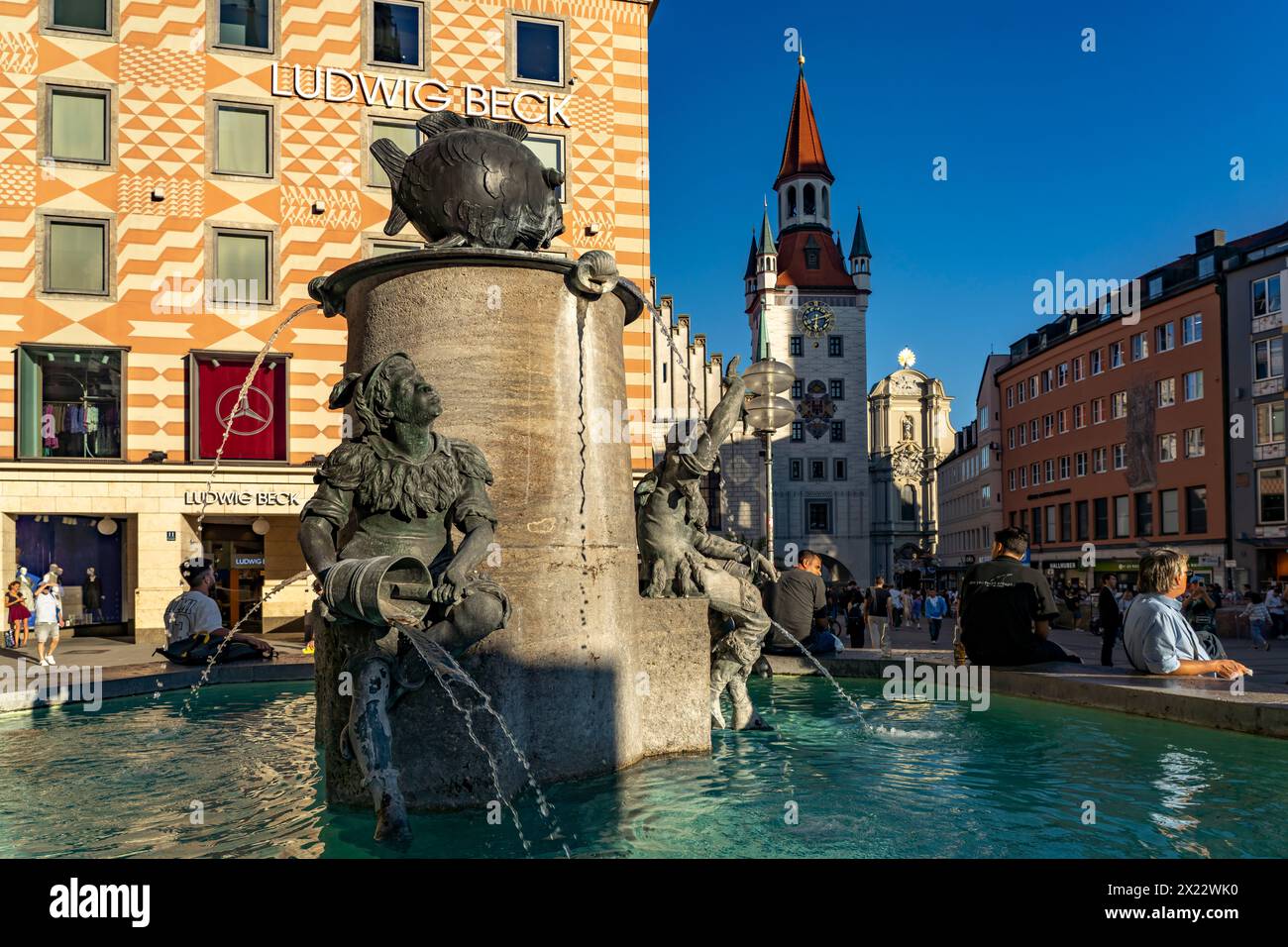 Fish fountain on Marienplatz, Ludwig Beck department store and Old Town ...