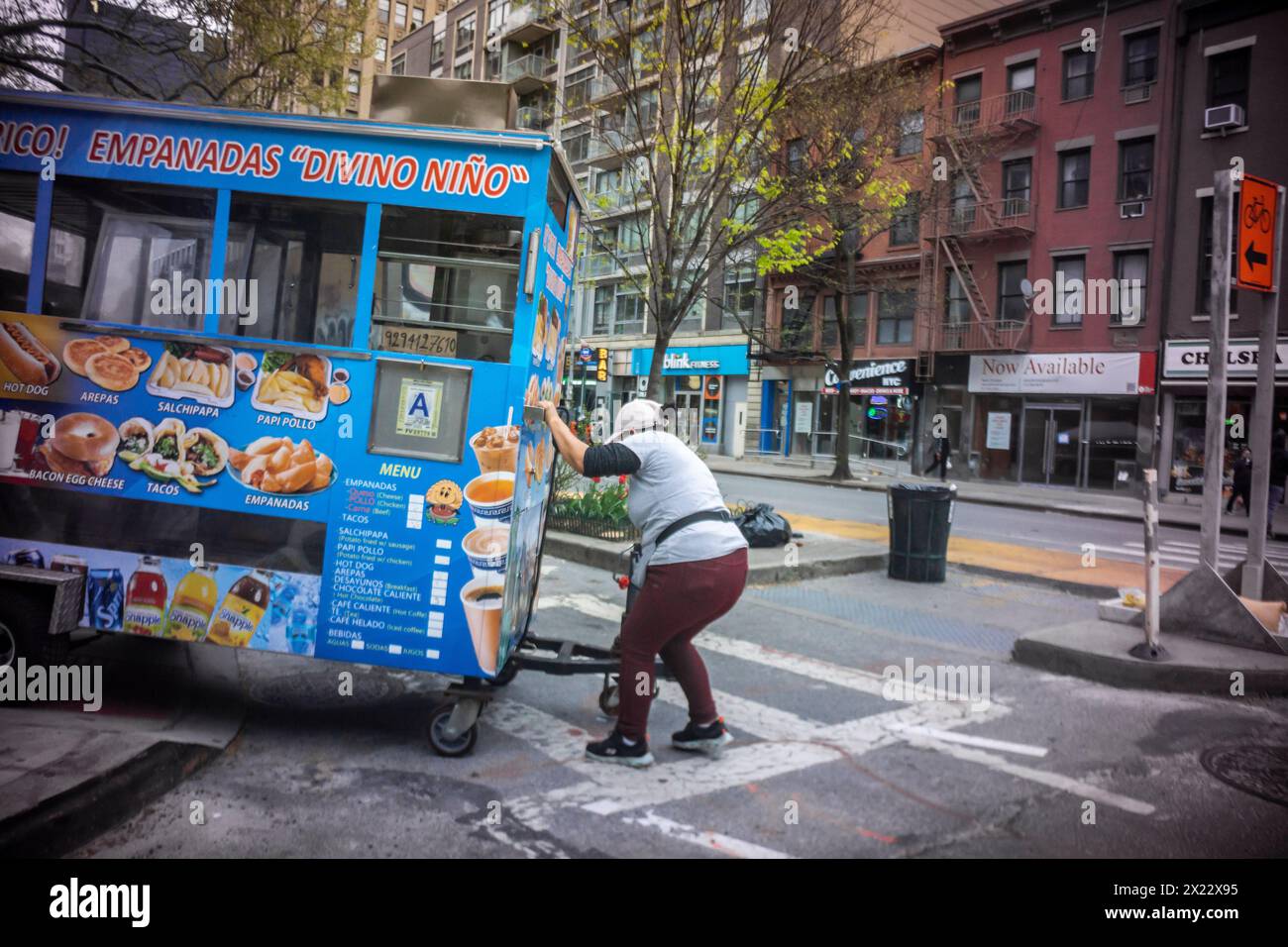 Food cart workers maneuver their cart off the sidewalk and into the ...