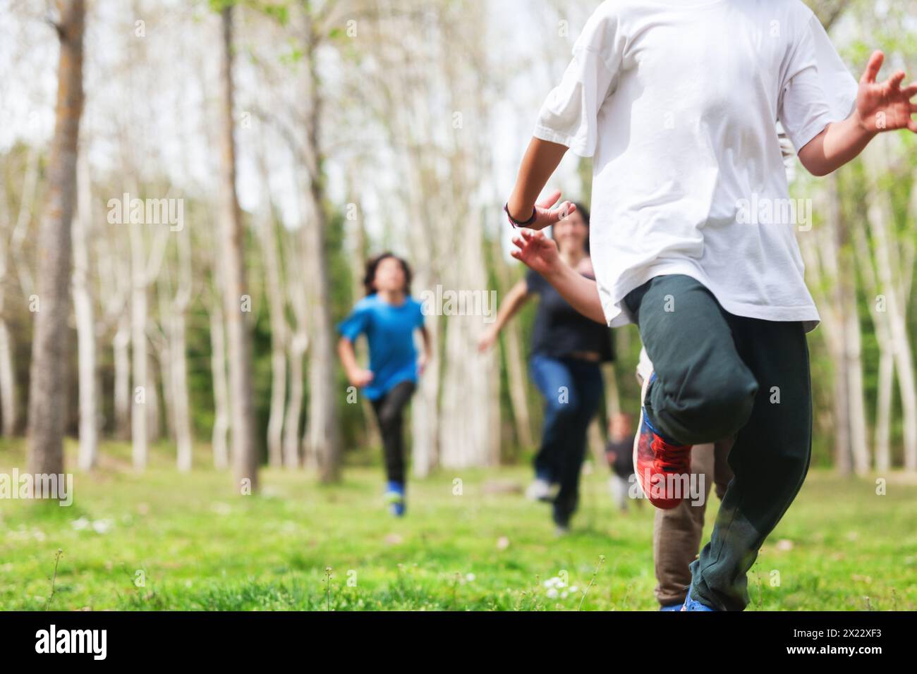 Close-up of a child's body running. Behind and out of focus, his ...