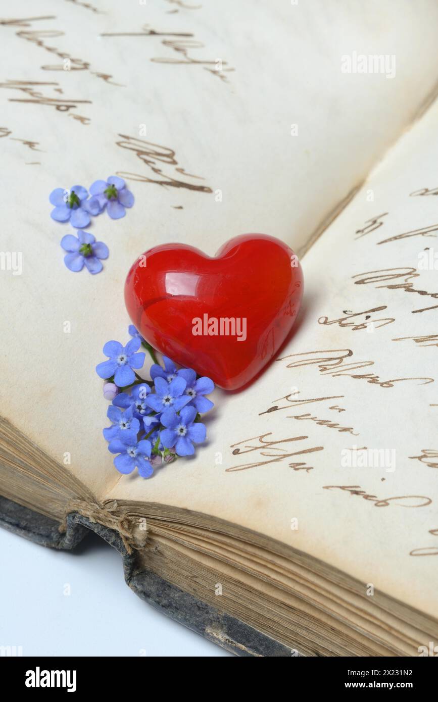 Red heart and forget-me-not flower on old diary Stock Photo - Alamy