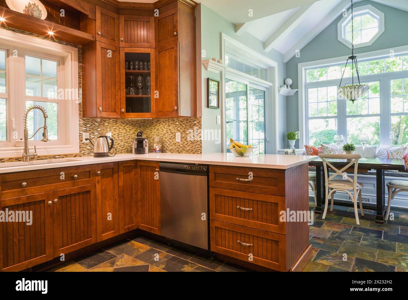Kitchen with cherry wood cabinets, earth tone slate flooring and ...