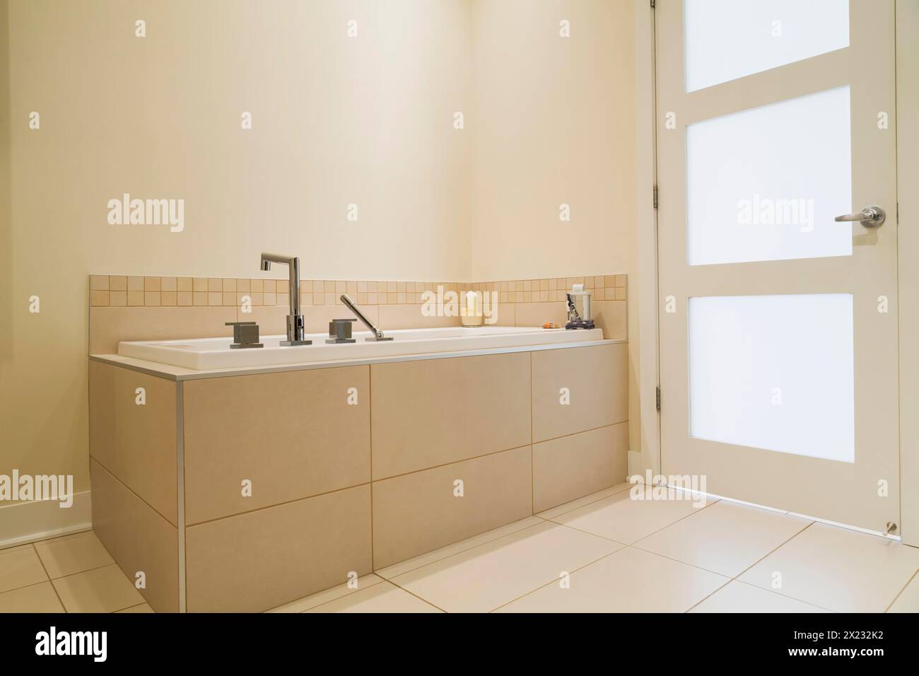 Soaking tub encased in a ceramic tile base in bathroom inside a ...