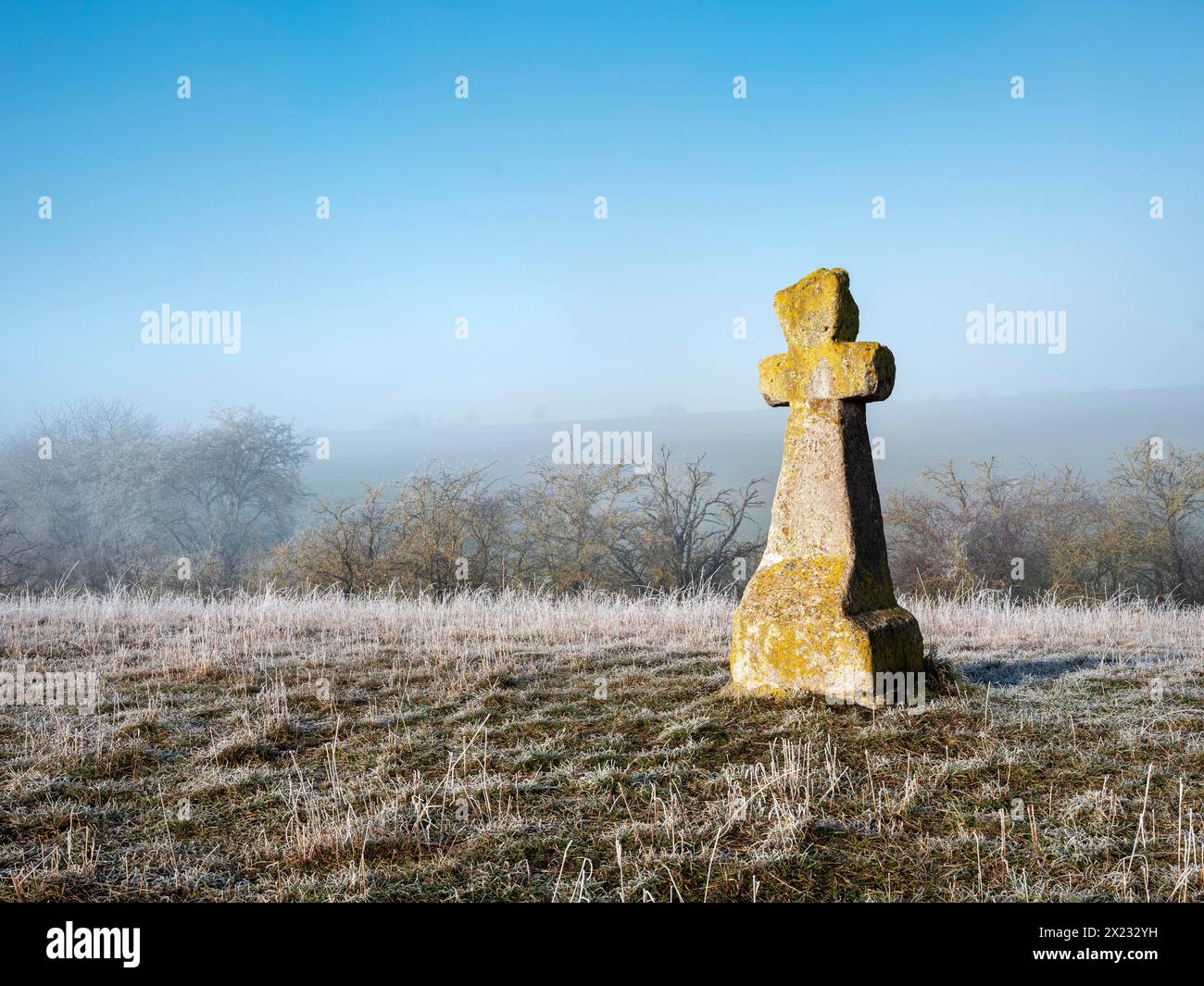Medieval stone cross in hoarfrost and fog in winter, murder cross ...