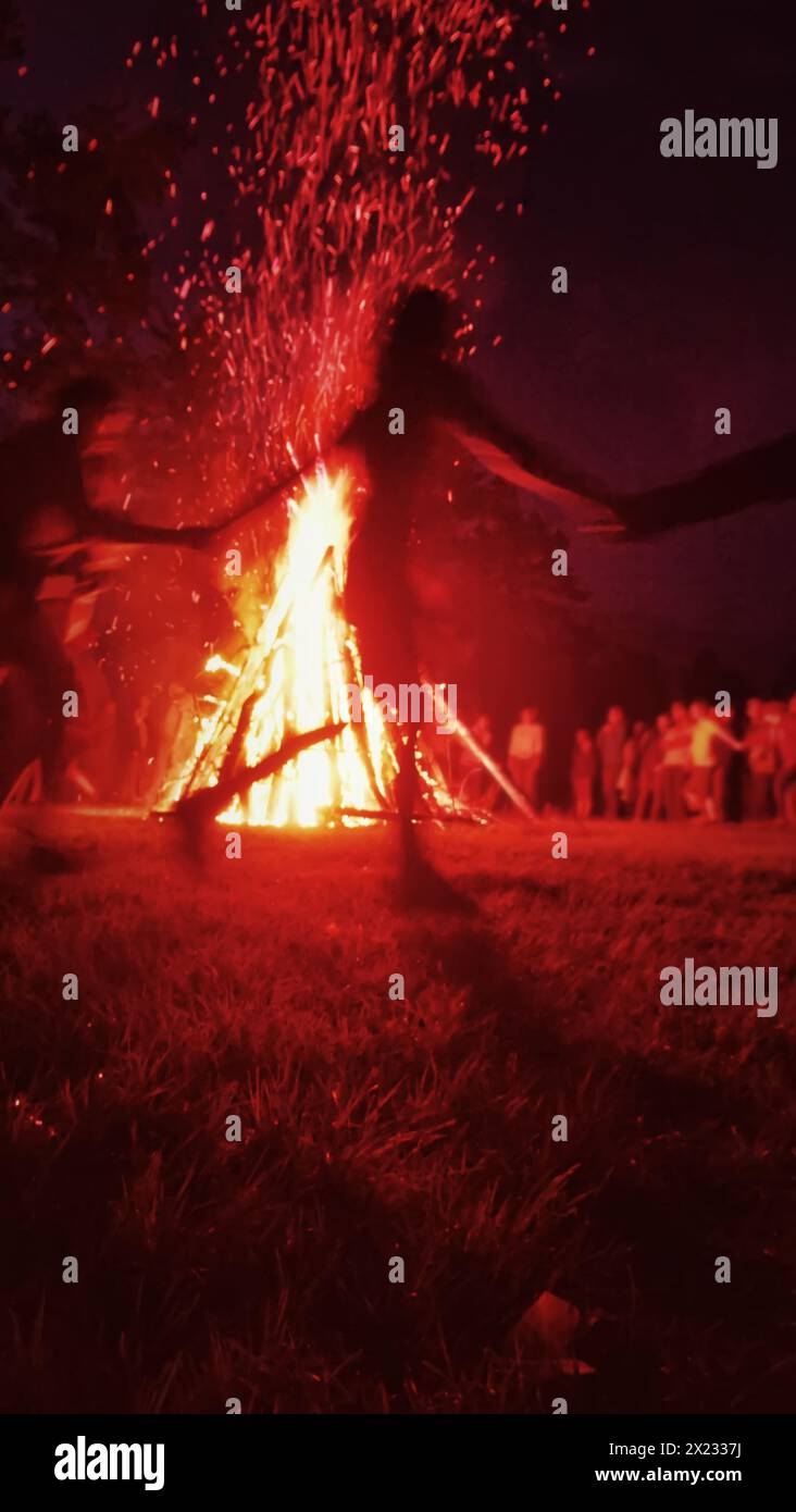 Huge fire at night and young people around. Pagan festival of Walpurgis ...