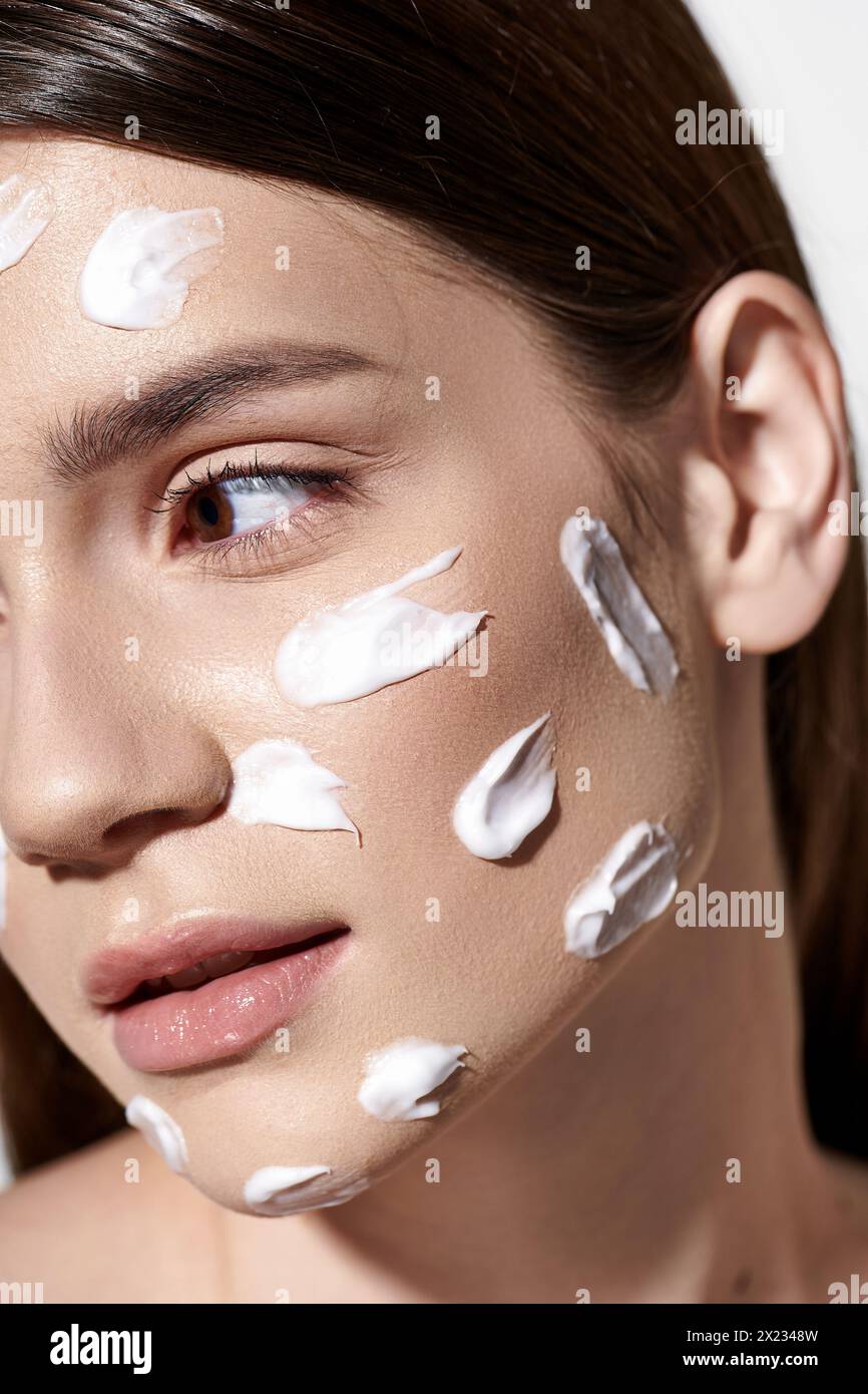 A stunning young woman with a generous amount of white cream gracefully ...