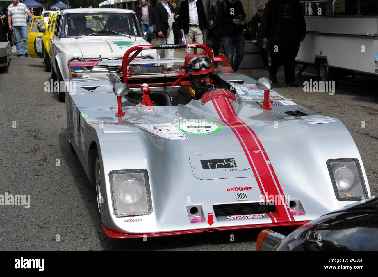A white and red endurance racing car with drivers on a race track ...