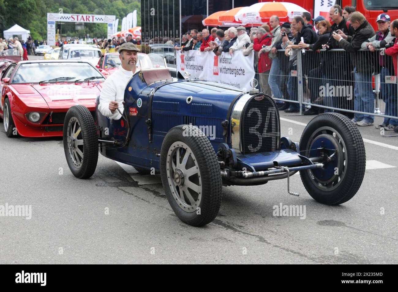 A historic blauer racing car at the starting line with driver in helmet ...