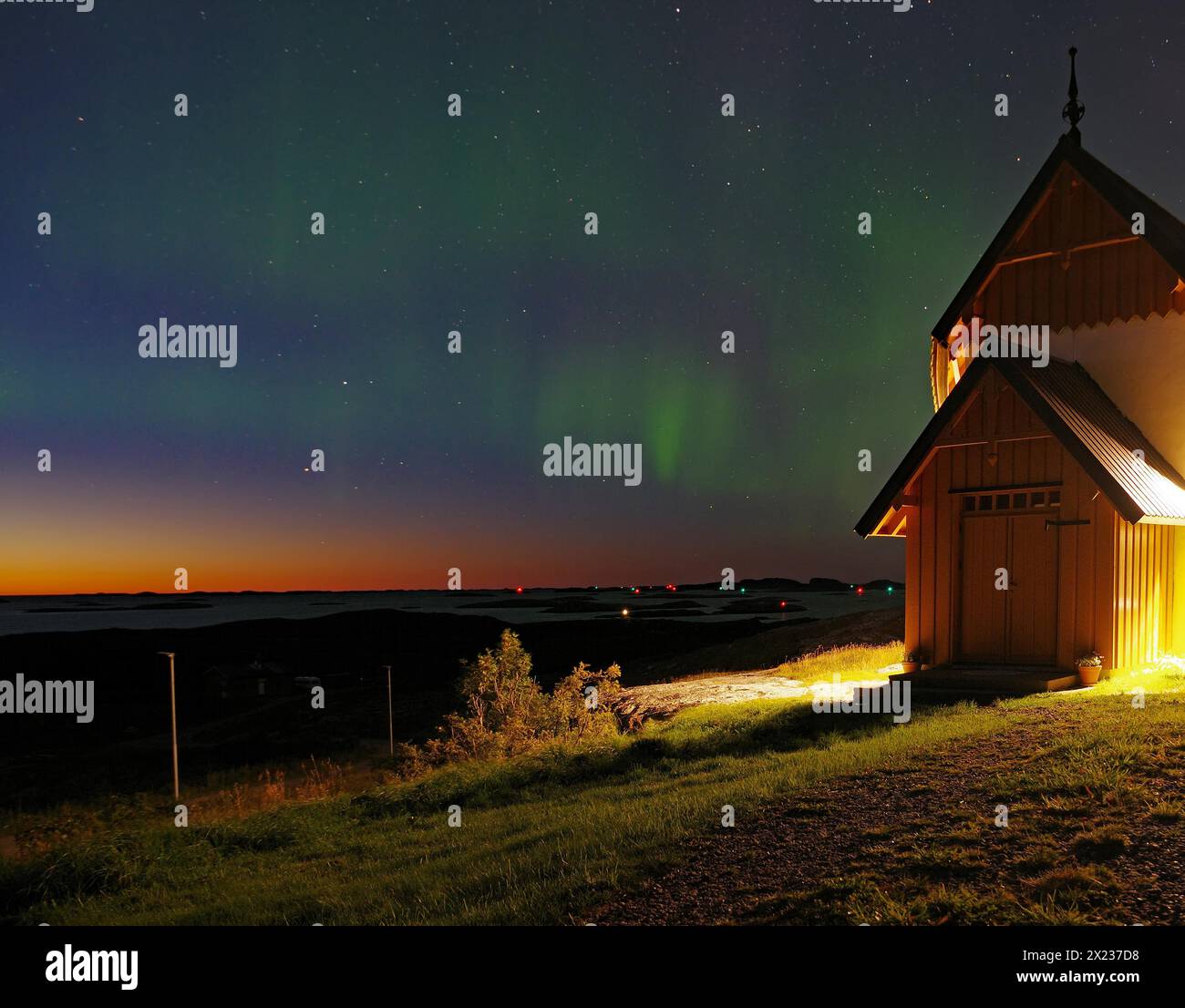 Northern lights (aurora borealis) merging with sunset, Petter Dass Chapel, night shot, Lovunden ...