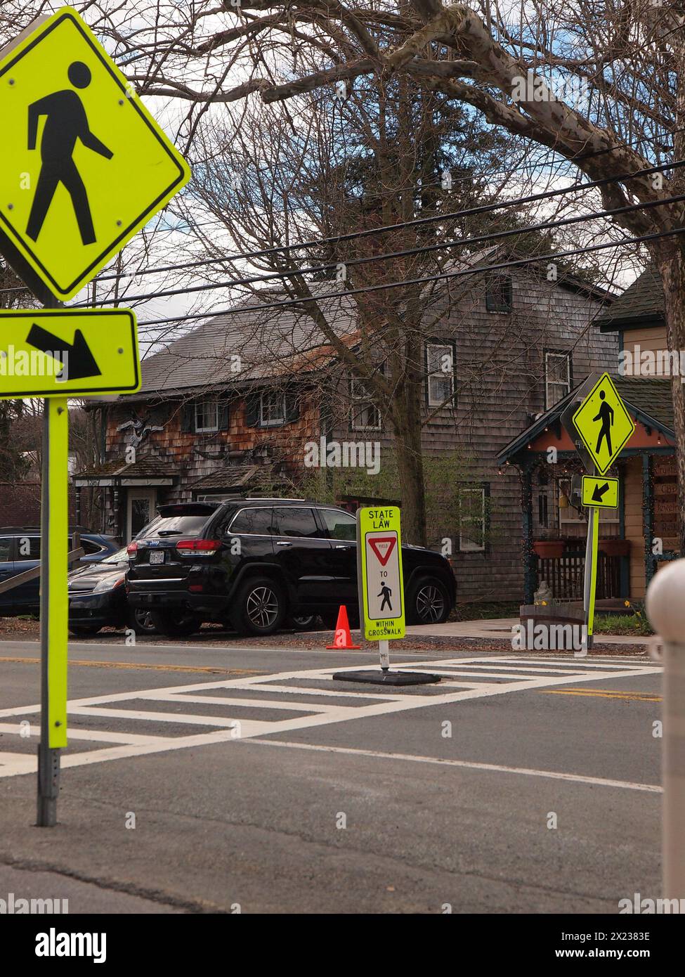Pedestrian crosswalk at a narrow street with warning signs. Distinctive ...