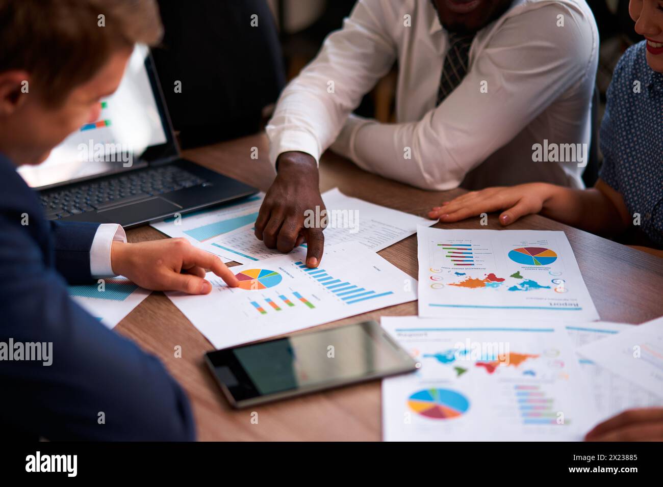 Diverse team at work in office, analyzing charts, diagrams on papers ...