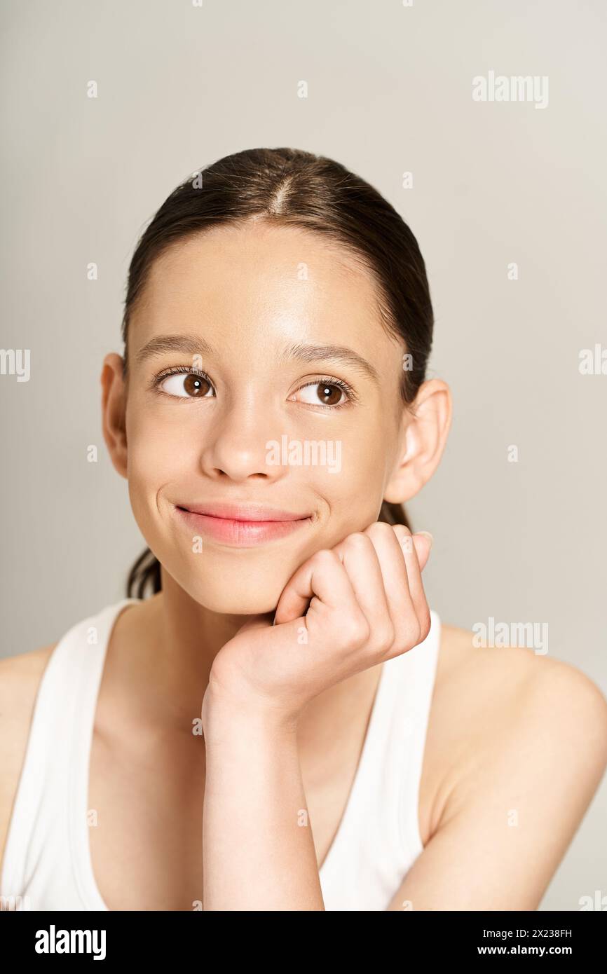 Teenage girl in vibrant attire striking a thoughtful pose, hand on chin ...