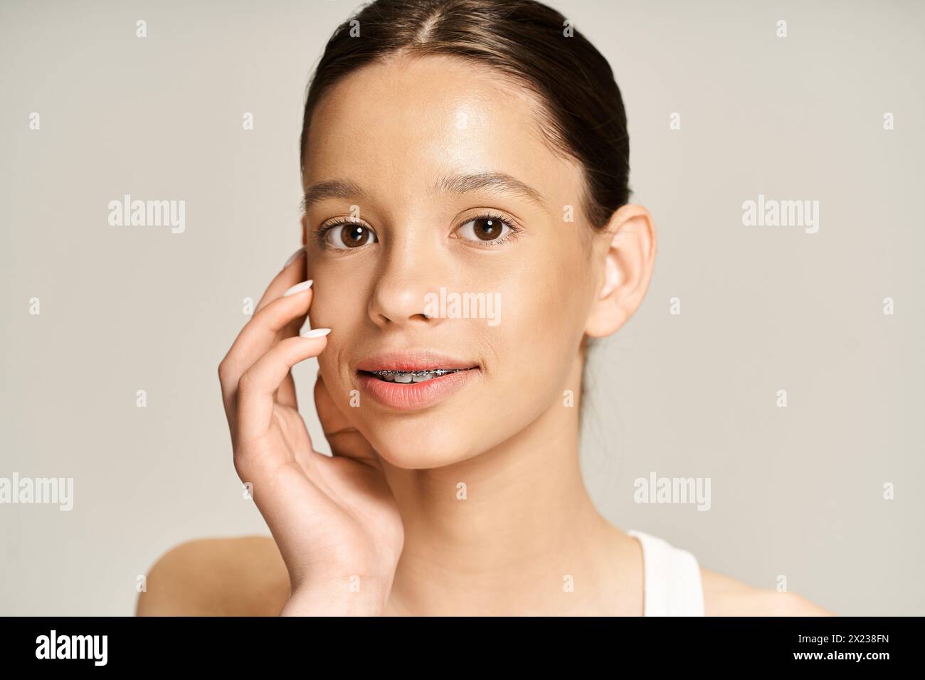 A teenage girl in stylish vibrant attire gracefully raises her hand to ...