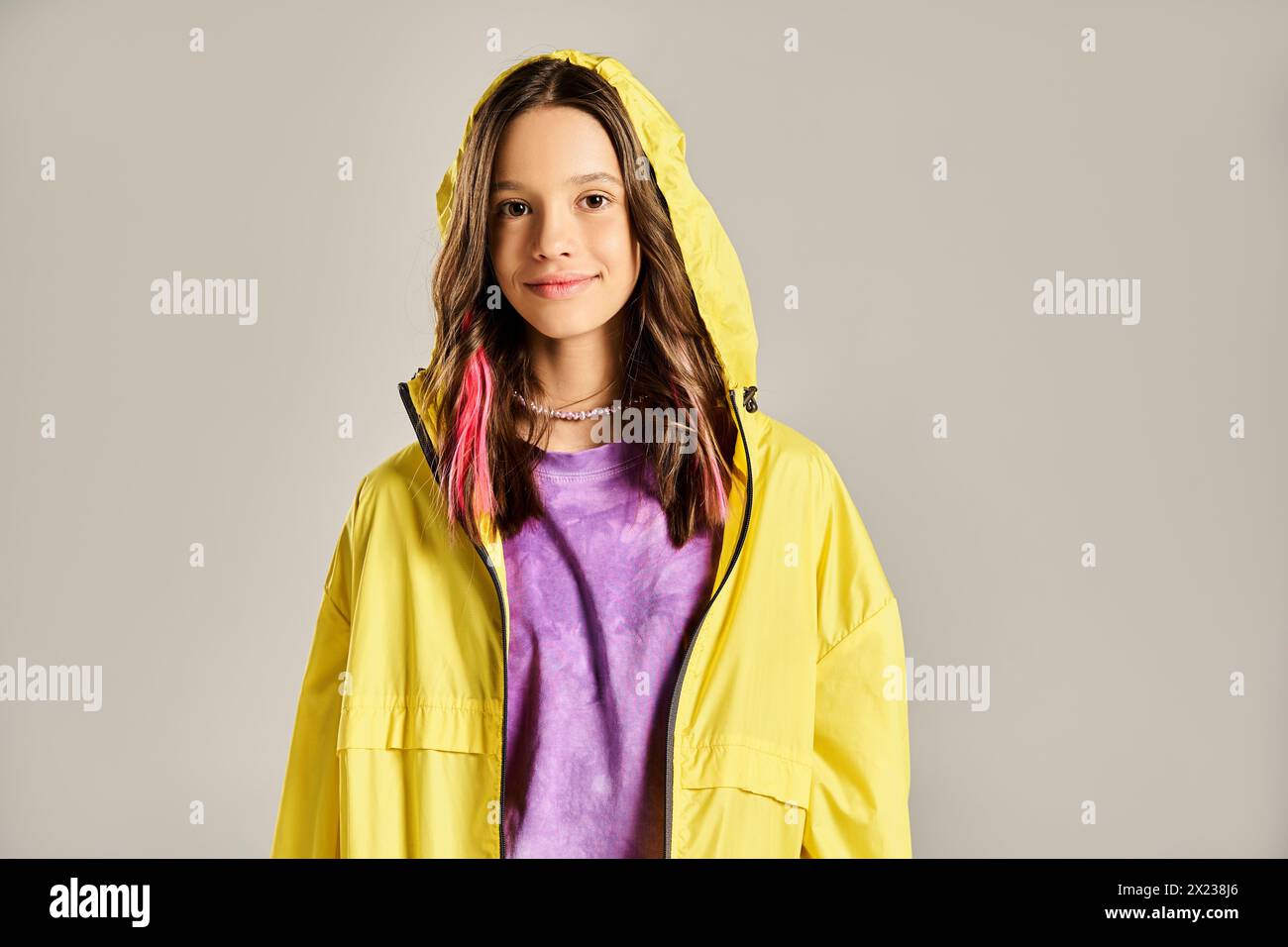 A fashionable teenage girl strikes a lively pose in a bright yellow ...