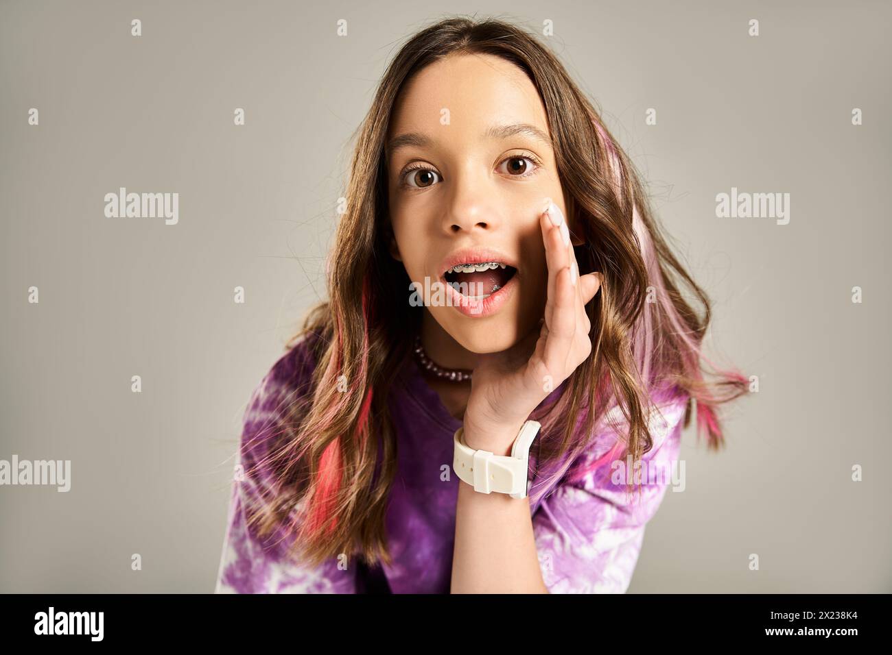 A stylish and lively teenage girl striking a comical pose, hand held up ...