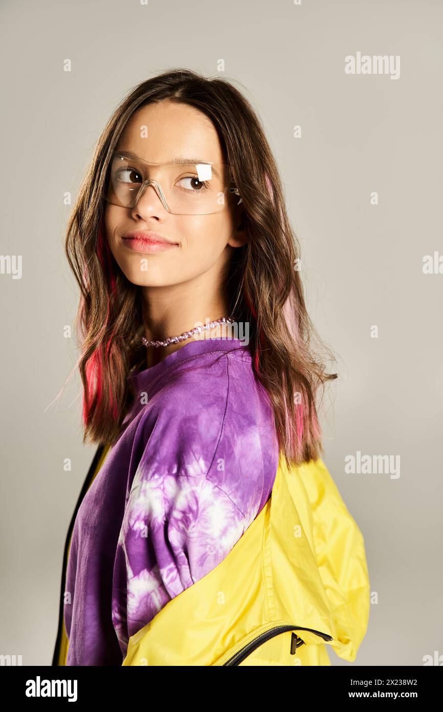 A stylish teenage girl poses confidently in a yellow and purple jacket ...
