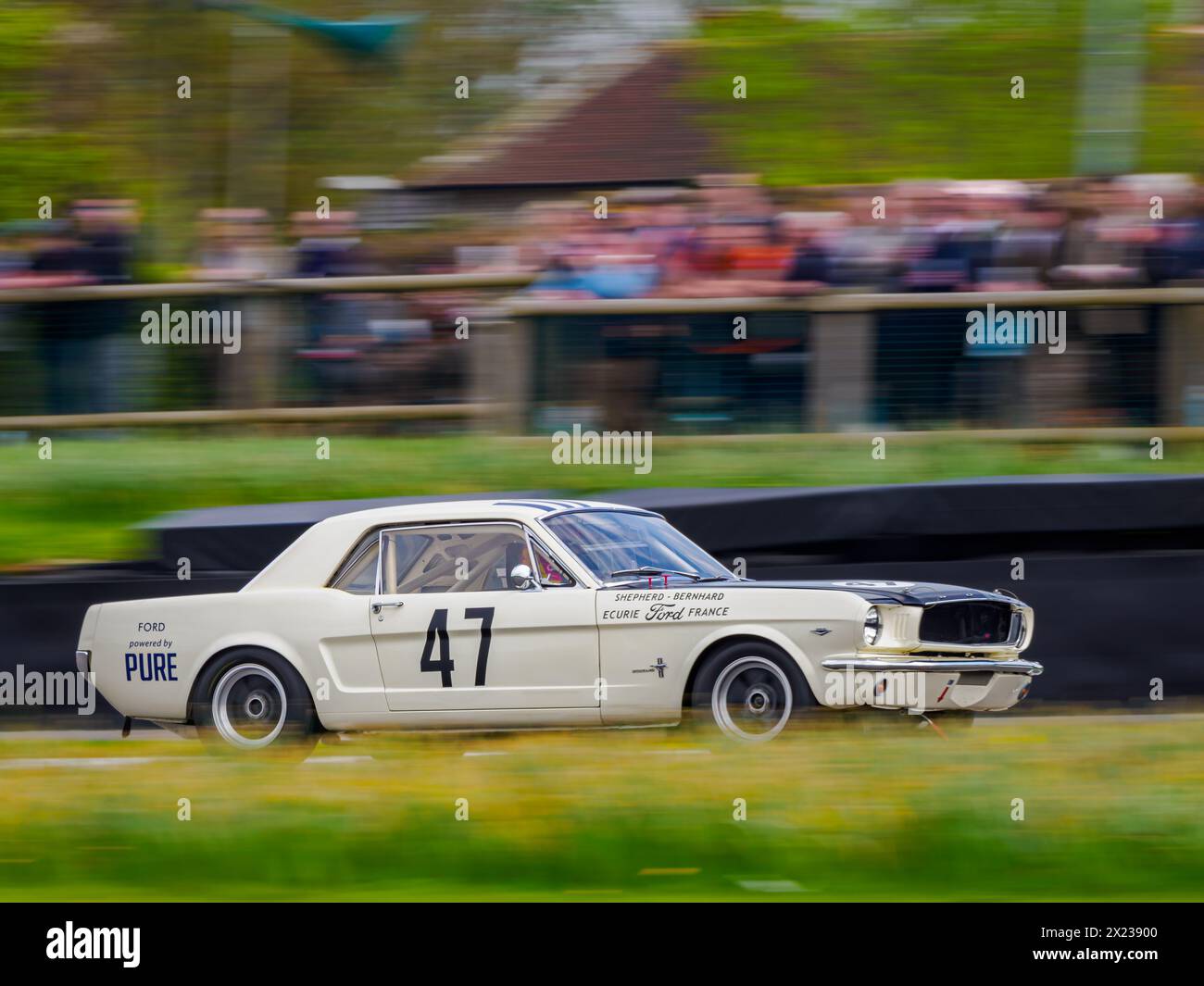 A white 1965 Ford Mustang racing in the Ken Miles Cup, Goodwood Members ...