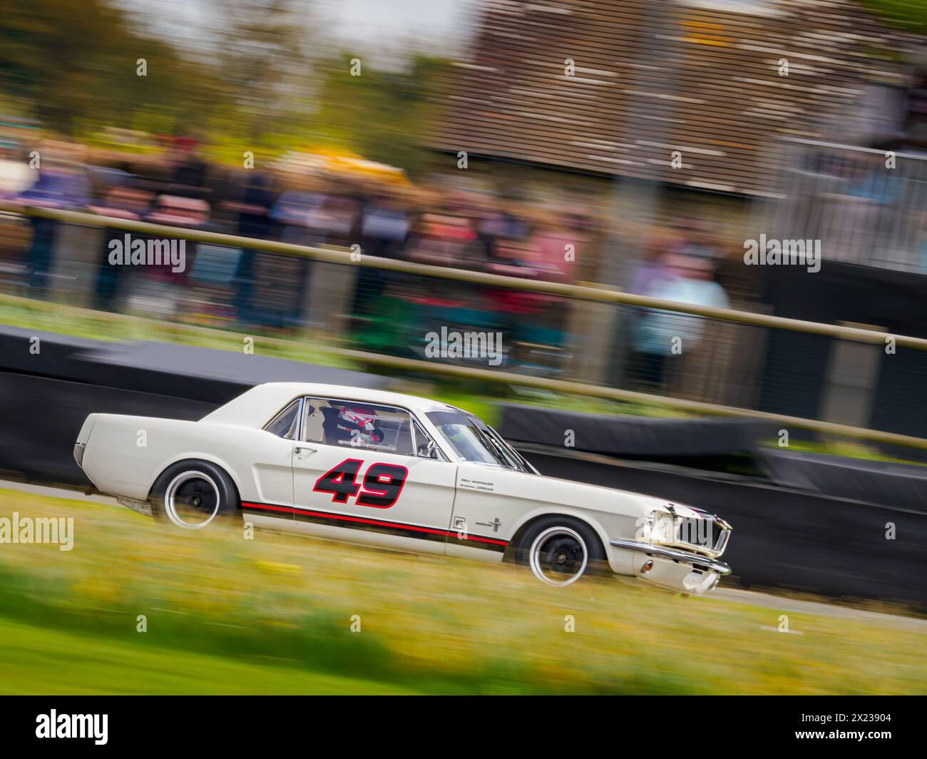 A white 1965 Ford Mustang racing in the Ken Miles Cup, Goodwood Members ...