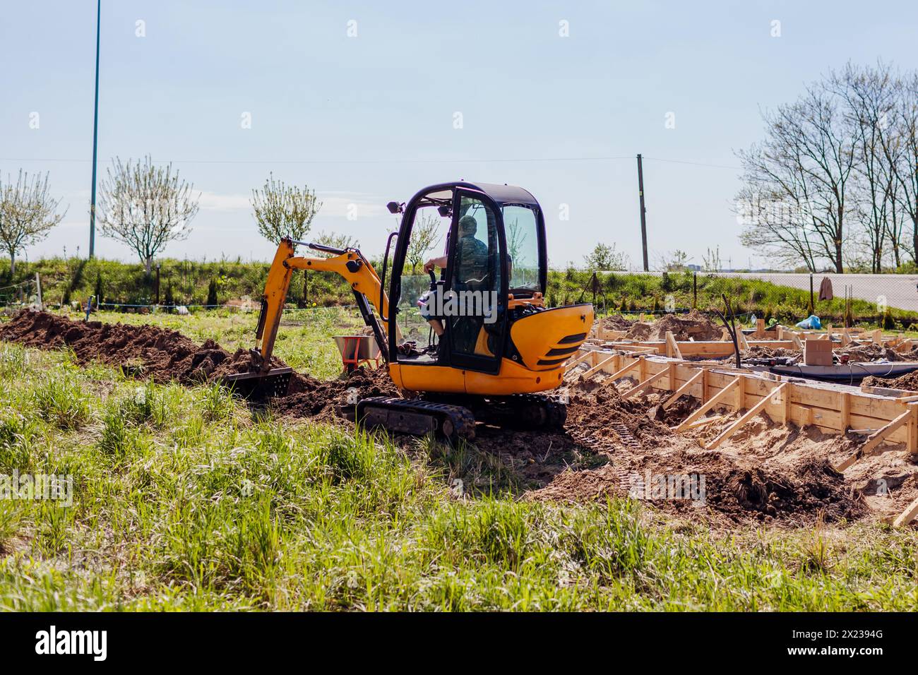 Yellow excavator digging foundation house hi-res stock photography and ...