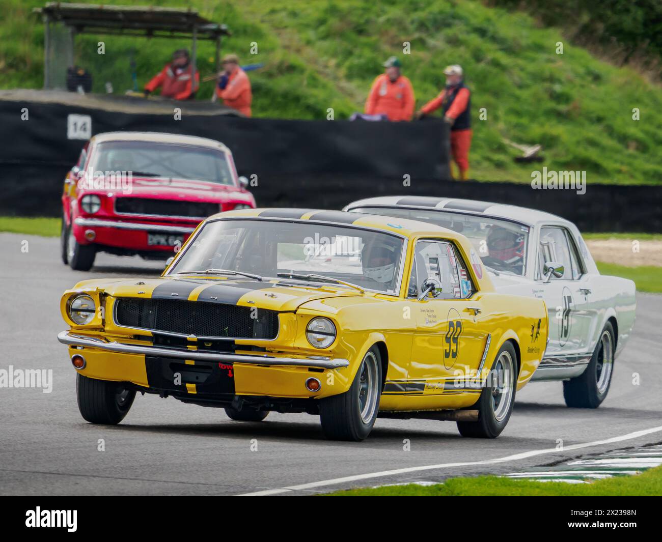 A yellow 1965 Ford Mustang (Mustang Sally) racing in the Ken Miles Cup ...